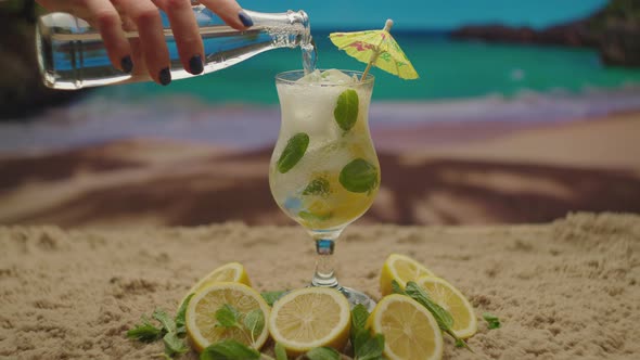 Hand Pouring Soda Into Glass of Fresh Cold Lemonade Rotating on the ...