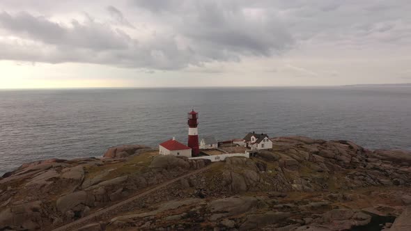 Ryvingen lighthouse at sunset - Red and white lighthouse on small ...