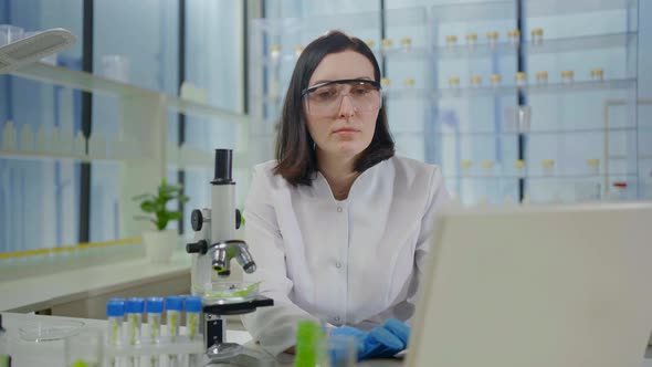 Dissatisfied and Puzzled a Female Scientist Looks Through a Microscope ...