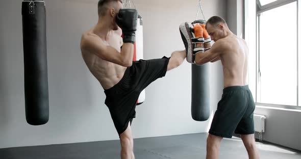 The Kickboxer is Practising His Middle Kick with Trainer in Slow Motion ...