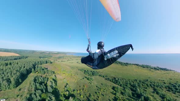 A Person Is Flying the Parawing Above the Green Fields, Stock Footage