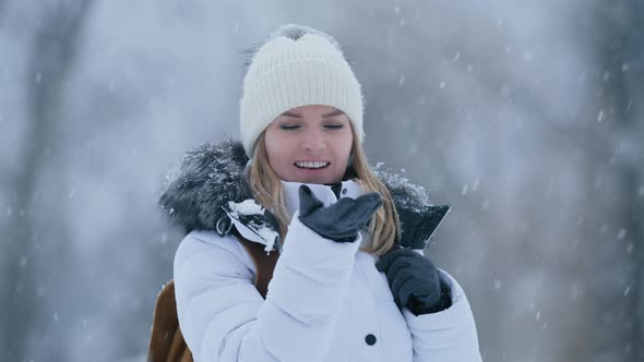 Carefree Attractive Young Woman Trying to Catch Snowflake on the Palm of Hand 6K, Stock Footage