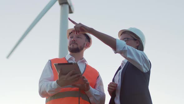 A Man and a Woman Engineers Look at a Modern Digital Tablet Into the ...