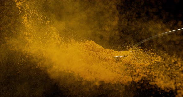 Spoon and Curry Powder falling against Black Background, Slow motion 4K ...