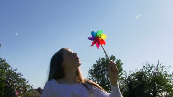 Female blowing on a pinwheel, Stock Footage | VideoHive