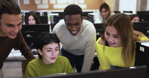 Young multiracial students using computer inside classroom at ...