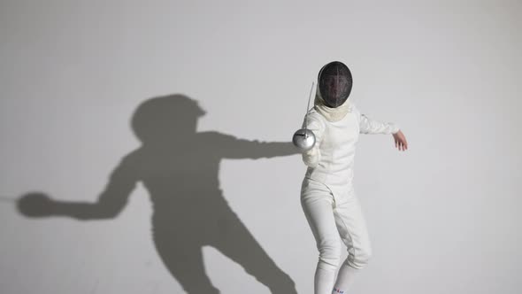Portrait of a Young Woman Fencer Saluting with Rapier Putting on Helmet ...