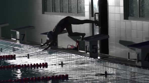 Male Swimmer Jumps Off Starting Block and Start Swims in Pool ...