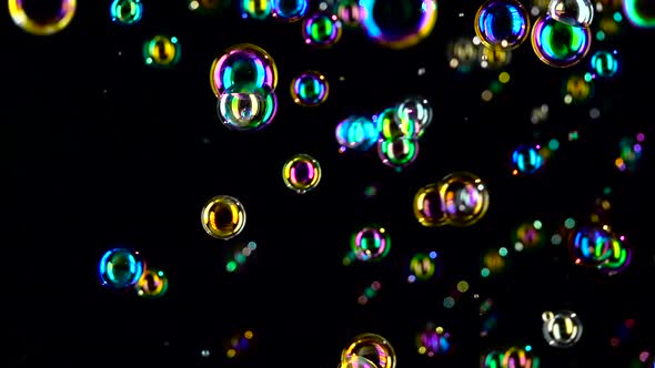 Soap Bubbles Fly and Fade in Different Colors. Slow Motion. Black ...