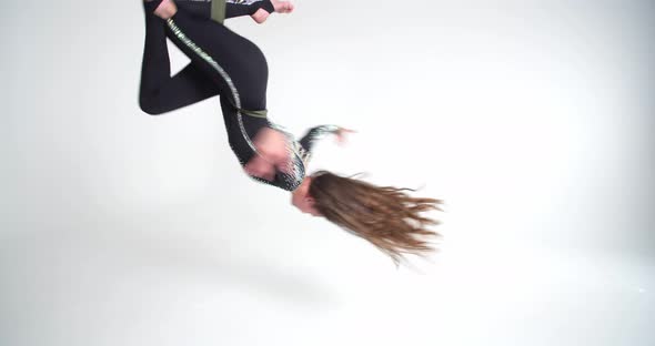 Upside Down Spin with a Split Woman Doing Aerial Silks in White Room ...