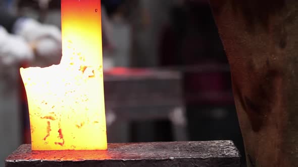 Blacksmiths forging hot metal with hammer in workshop, Stock Footage