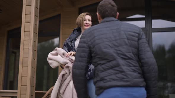 Smiling Beautiful Woman Standing on Porch Covering Man with Blanket ...