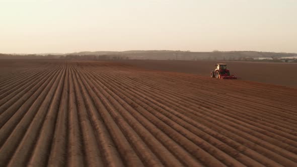 Contemporary Tractor Drags Plug Making Furrows on Soil in Field at ...