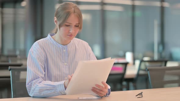 Young Woman Reading Reports While Sitting in Office, Stock Footage