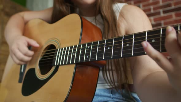Closeup woman hand plays music on acoustic guitar, fingering strings ...