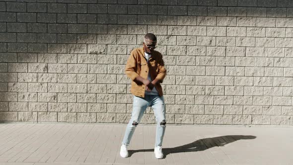 Portrait of Happy Guy Dancing Outside Against Wall Background ...