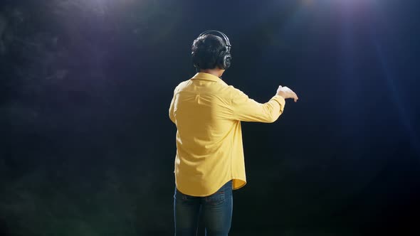 Back View Of A Young Boy With Headphone Holding A Microphone And ...