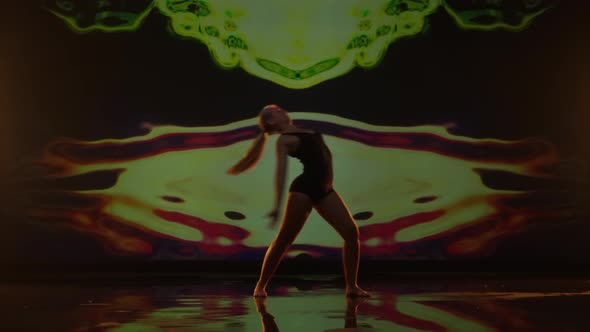 Artistic Young Woman Dancing Against Dark Animated Background on a ...