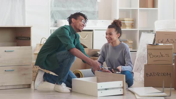 Two Young People Fixing Cabinet Drawer Using Online Instruction, Stock ...