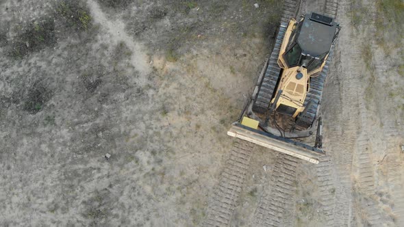 Top Aerial View on Tracked Bulldozer Rides on Sandy Road at ...