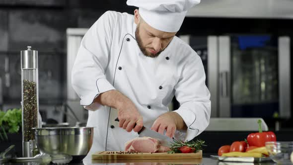 Male Chef Cutting Meat Slice at Professional Kitchen. Chef Preparing ...