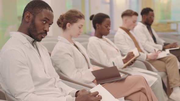 Diverse Medical Students in Row Taking Notes at Lecture, Stock Footage