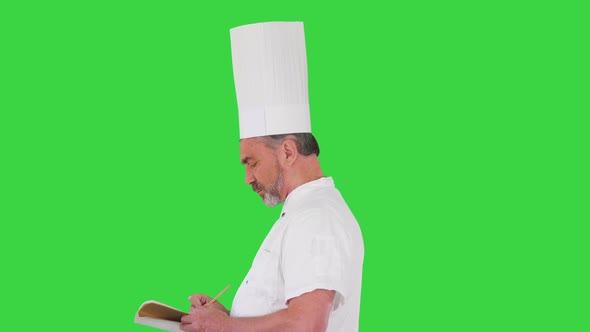Male Chef Cook Making Notes on a Green Screen Chroma Key, Stock Footage