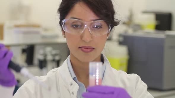 Scientist dropping liquid into vial in genetic laboratory, Stock Footage