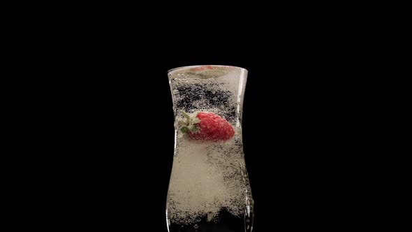 Strawberry in champagne flute at slow motion. Fruit berry splashing in ...