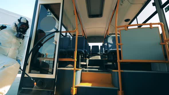 Sanitation Worker Is Entering a Bus and Sanitizing It, Stock Footage