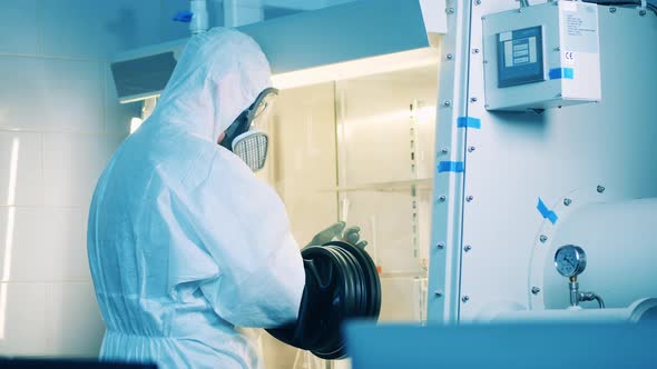 Lab Worker in a Hazmat Suit is Using a Vacuum Cabinet for Research ...