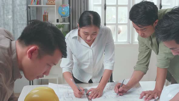 Group Of Asian Engineers Helping Each Other Drawing Building ...