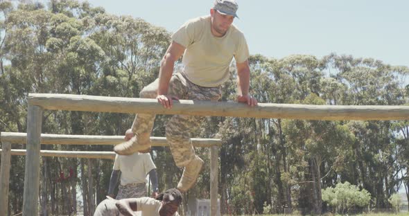 Diverse group of male soldiers going over and under hurdles on army ...
