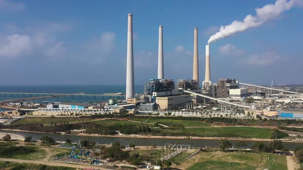Hadera Park, Orot Rabin Power plant aerial pull out shot with blue sky ...