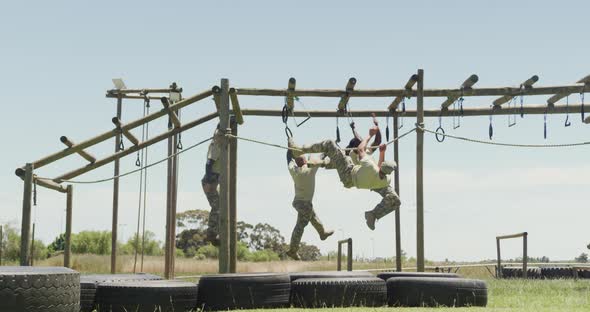 Fit diverse group of soldiers using hanging rope and rings on army ...