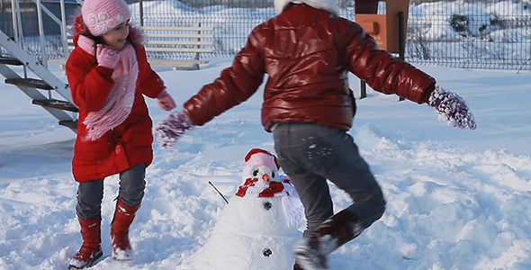 Happy Girls Running Around a Snowman, Stock Footage | VideoHive