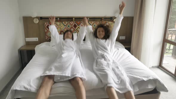 Happy Man and Lady Fall on Bed Joining Hands in Hotel, Stock Footage