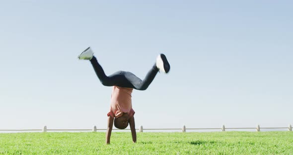 Video of happy african american boy doing cartwheel outdoors, Stock Footage