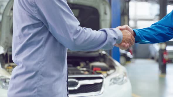 Asian automotive mechanic repairman doing handshake after handing car ...
