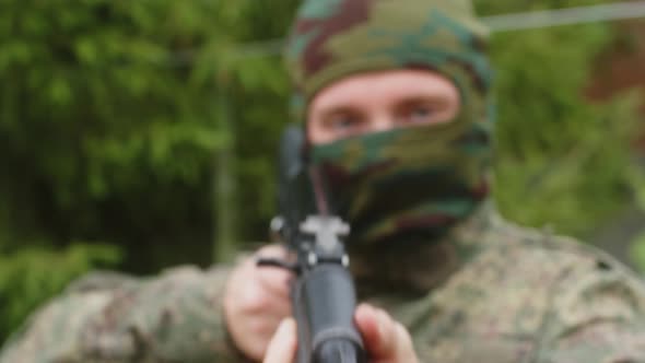 Closeup of a Masked Soldier Preparing to Fire and Pointing the Machine ...