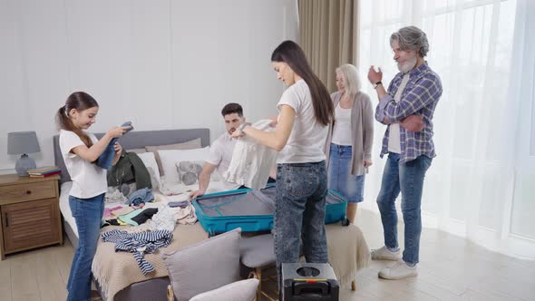 Big Family Packing Clothes Into Suitcase Before Plane Flight Preparing ...