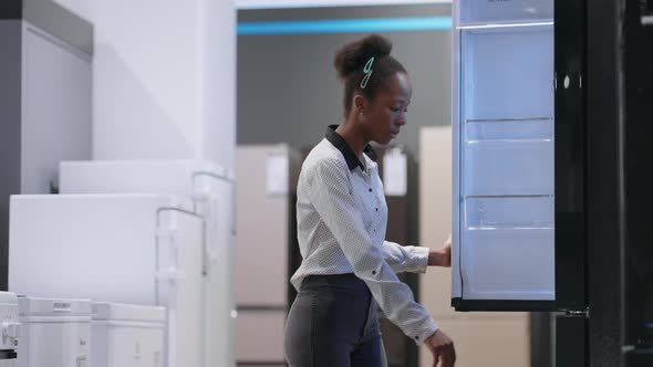 Afroamerican Housewife is Choosing Fridge in Home Appliance Store ...