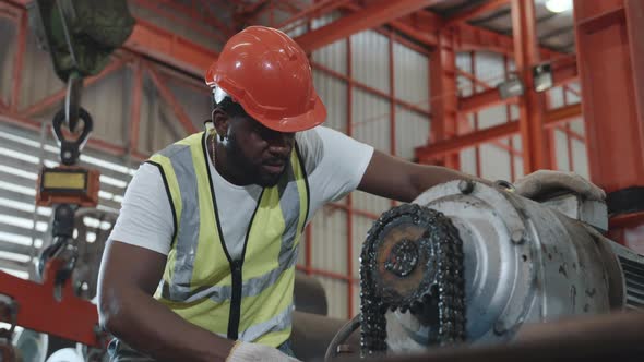 Engineer or operator wearing a safety suit maintaining machine in the ...