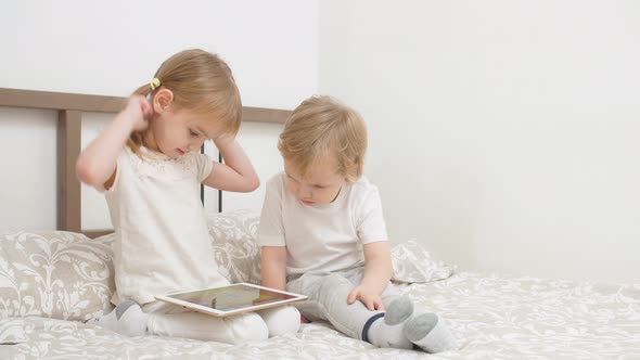 Little Caucasian Kids Use Tablet Sitting on Bed, Stock Footage | VideoHive