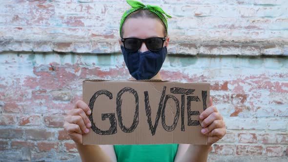 Woman shows cardboard Go Vote sign Voting balloting polling Political ...