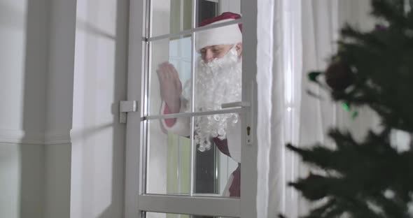 Santa Claus Standing Behind Glass Entrance Door and Waving As Cute ...