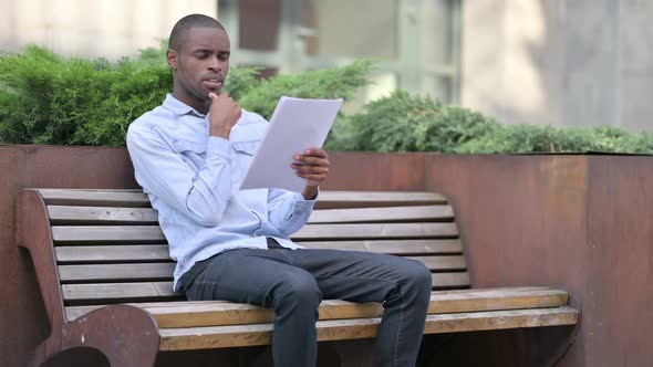 Pensive African Man Thinking While Reading Documents Outdoor, Stock Footage