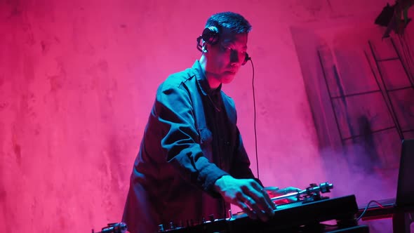 Modern DJ of Asian Appearance Performs a Music Track in Neon Lighting ...