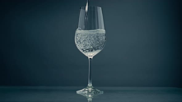 Bubbling Water Pouring Glass at Gray Background Closeup, Stock Footage