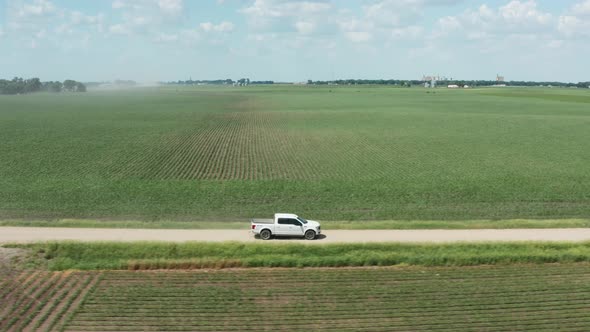 Aerial side view, white pickup truck driving on rural countryside ...